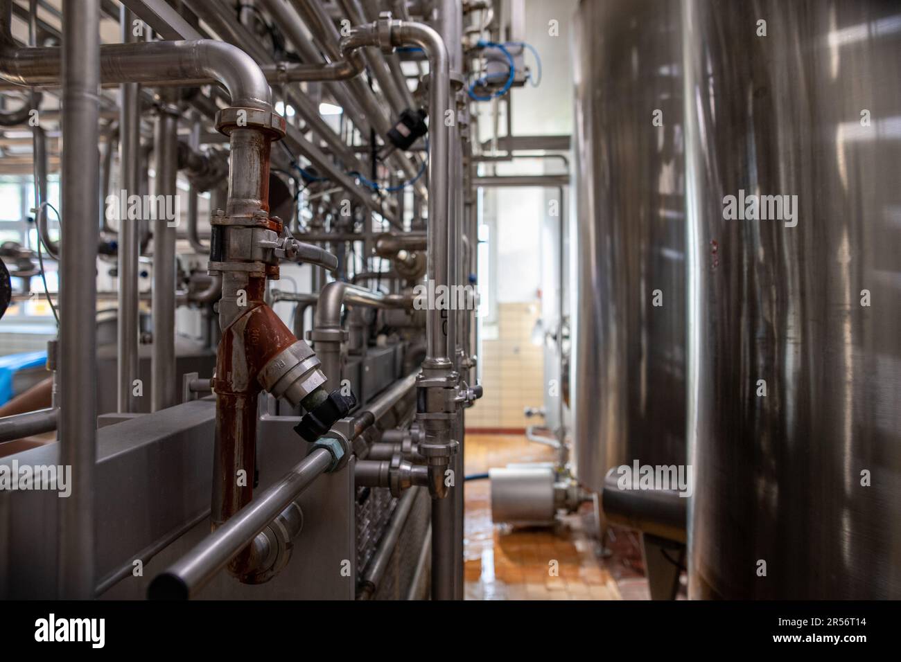 Interior of a modern manufacture with stainless steel tanks and pipes ...