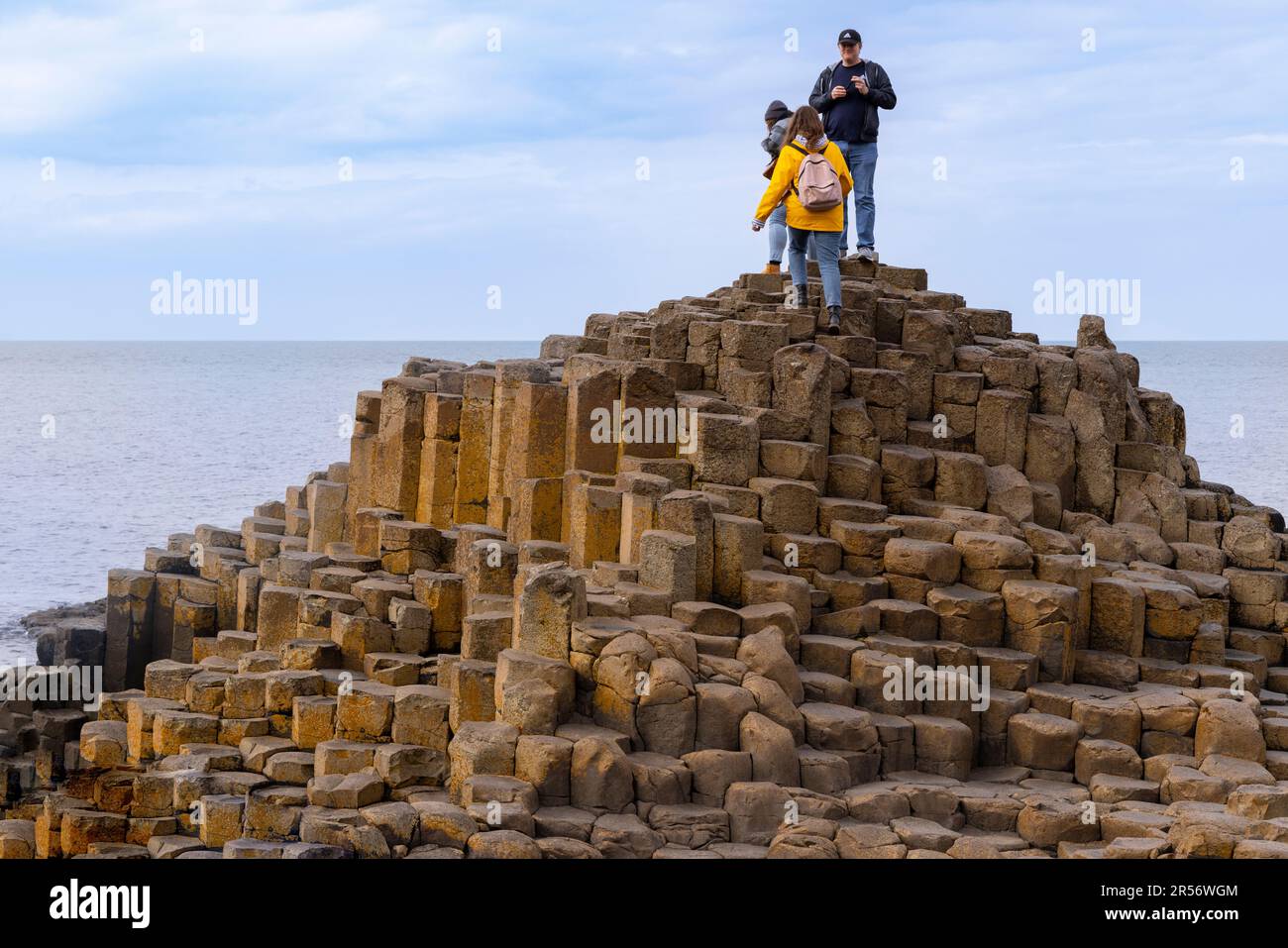 Tourists standing on the basalt formations at the Giant's Causeway ...