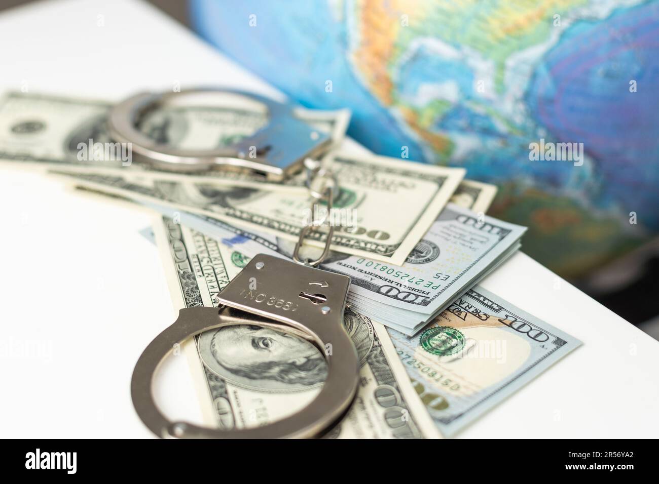 On a white table, handcuffs and a globe. Near a copy space. Cybercrime ...