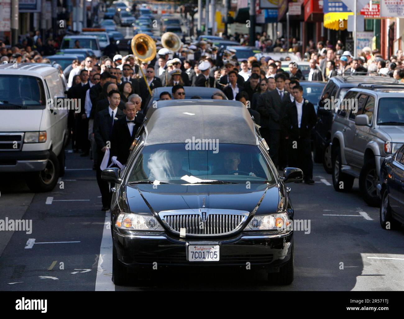 The hearse leads a funeral procession for Allen Leung down Clay Street ...