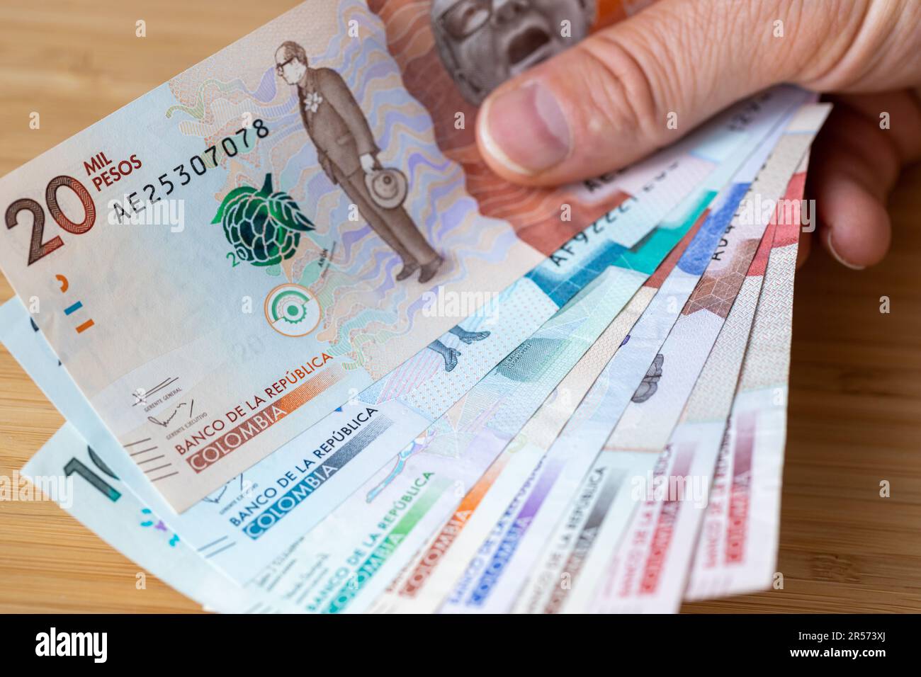 Colombia, Bundle of pesos banknotes held in hands, Financial concept ...