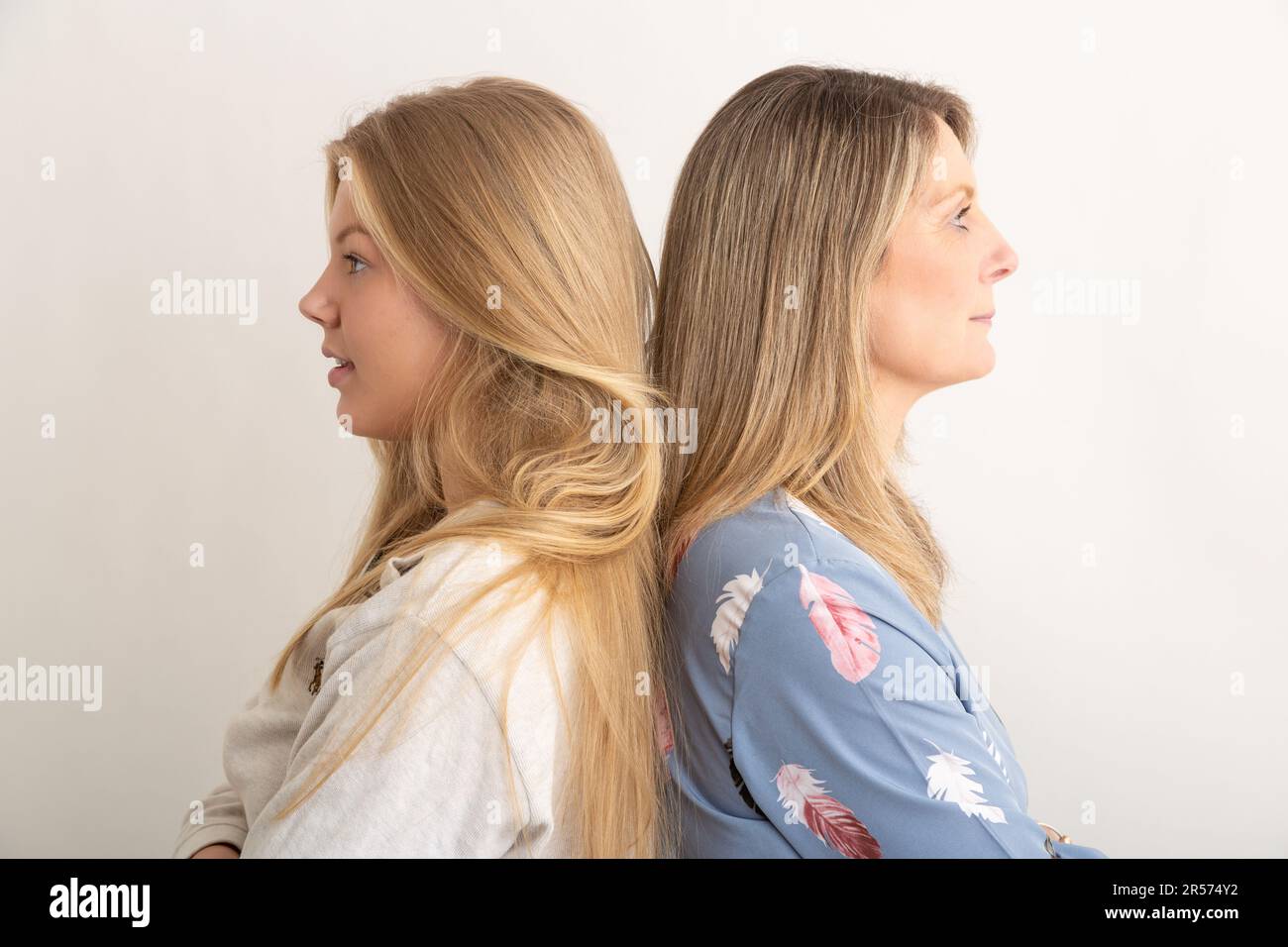 Mother & adult daughter standing back to back Stock Photo - Alamy