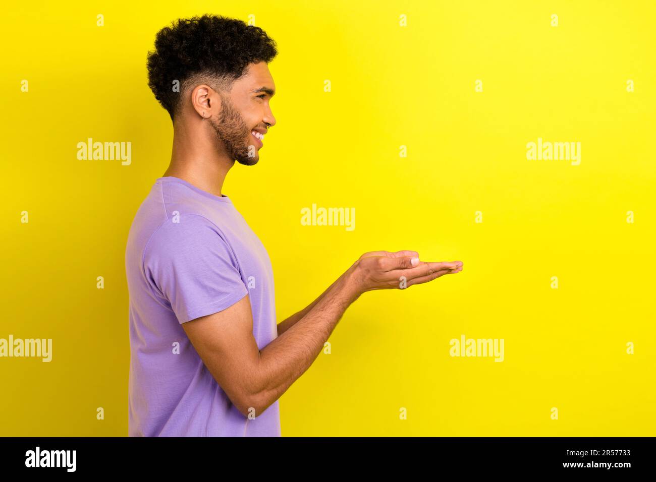 Photo of attractive cool man wear violet t-shirt holding arms empty ...