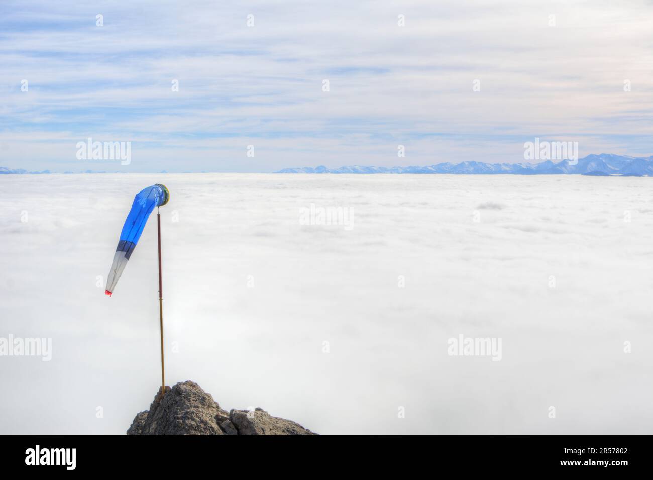A high vane on top of a mountain overlooking the snowless clouds ...