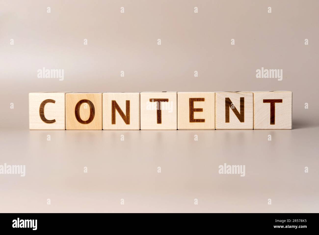The word CONTENT on wooden cubes on a beige neutral studio background ...