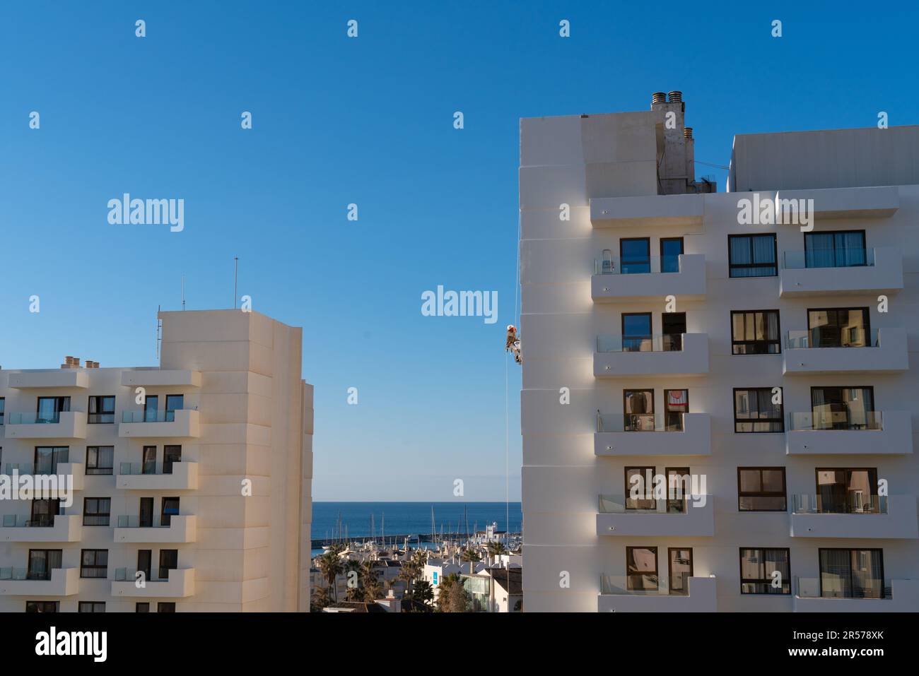 Painter doing high painting work on the side of a building at height on ...