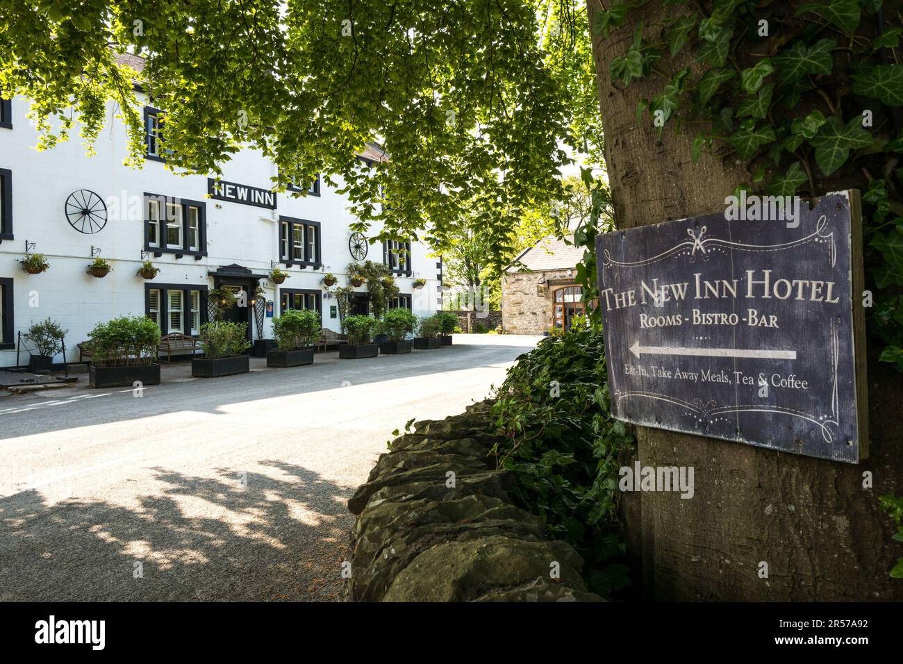 Sign pointing to the New Inn and Hotel attached to a tree in the ...