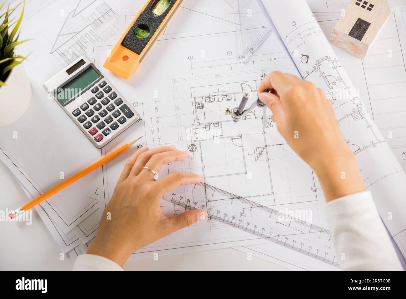 Architect drawing with divider compass on house plan blueprint paper ...