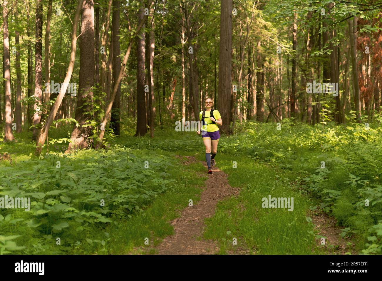 young woman jogging on a path in a natural forest park Stock Photo - Alamy