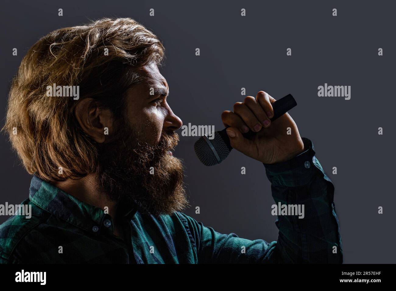 Man with a beard holding a microphone and singing. Bearded man in ...