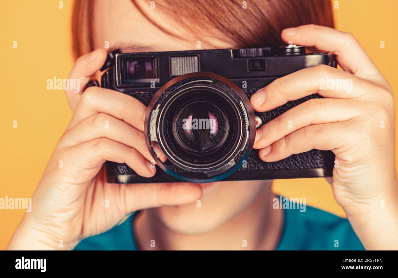 Cheerful smiling child holding a cameras. Little boy on a taking a ...