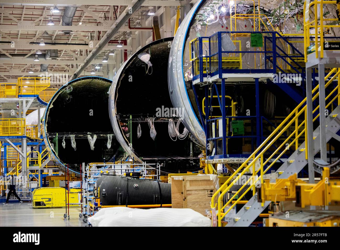 An employee walks past a fuselage section under construction at Boeing ...