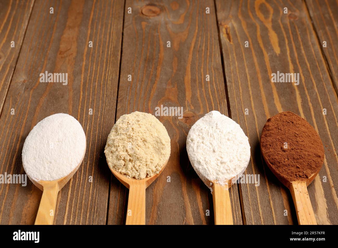 Wooden spoons with different types of flour and cacao on brown wooden ... Wooden spoons with different types of flour and cacao on brown wooden ...