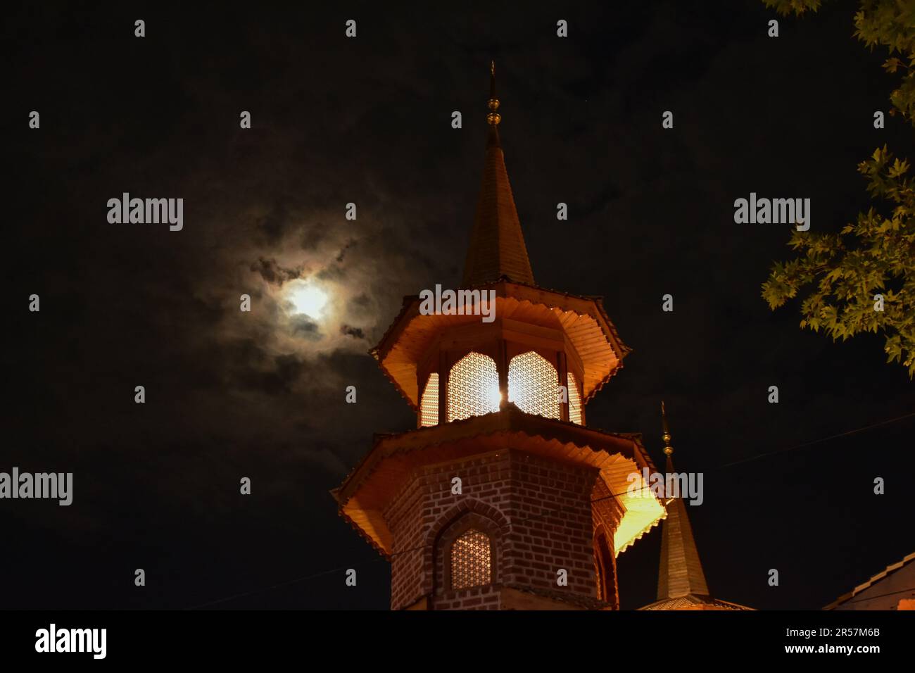 The moon rises over the minaret of Masjid Bilal (RA) during a cloudy ...