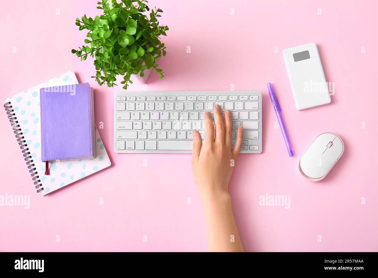 Female programmer using computer keyboard with mouse and notebooks on ...