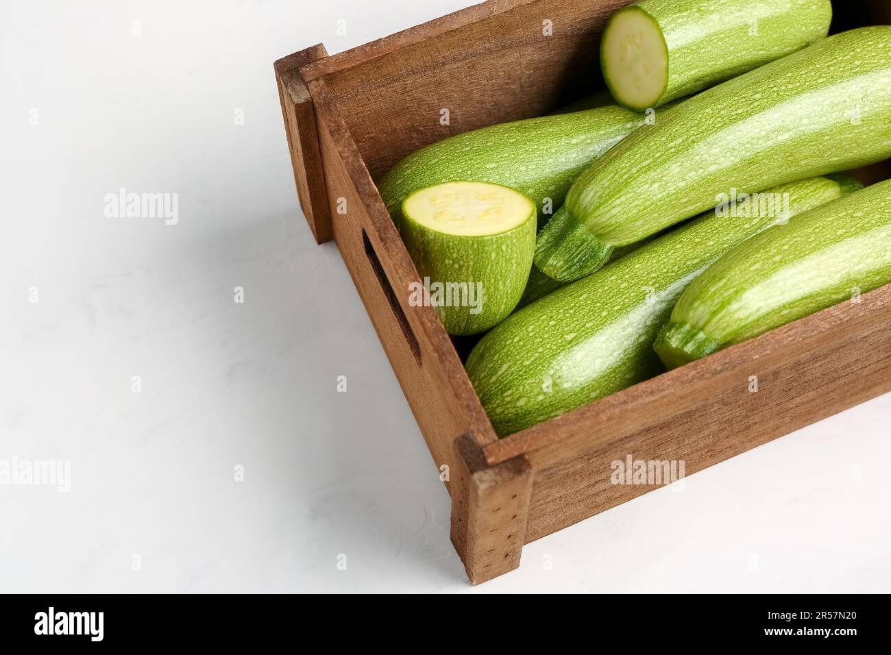 Wooden box with fresh green zucchini on white background Stock Photo ...