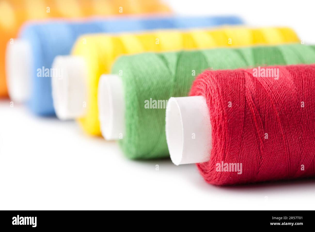 Pile of coloured bobbins of thread isolated on white Stock Photo - Alamy