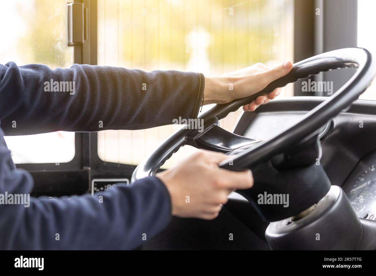 Close up of bus driver hands on the steering wheel during driving the ...