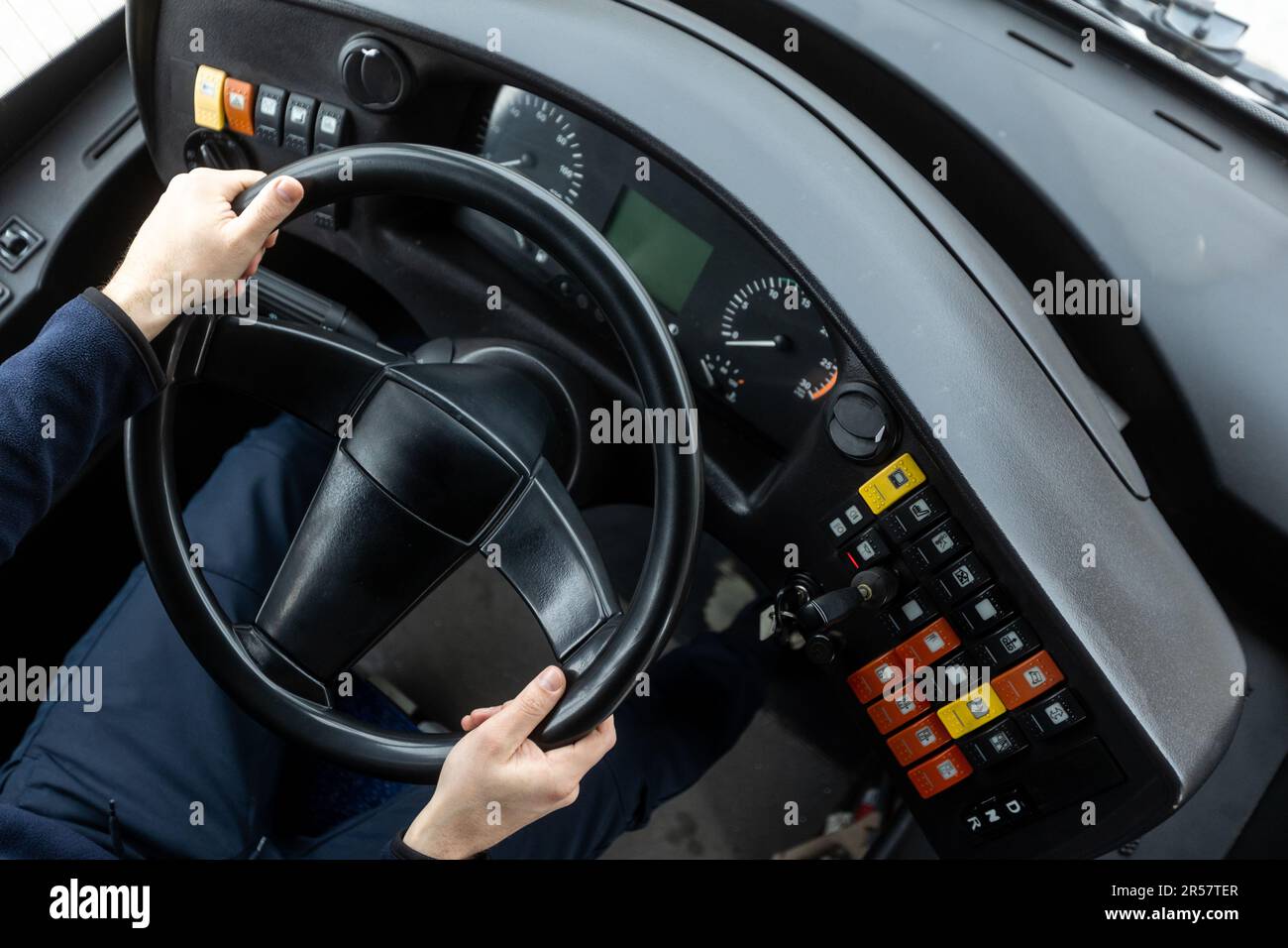 Cockpit or cabin of public transport, bus driver holding steering wheel ...