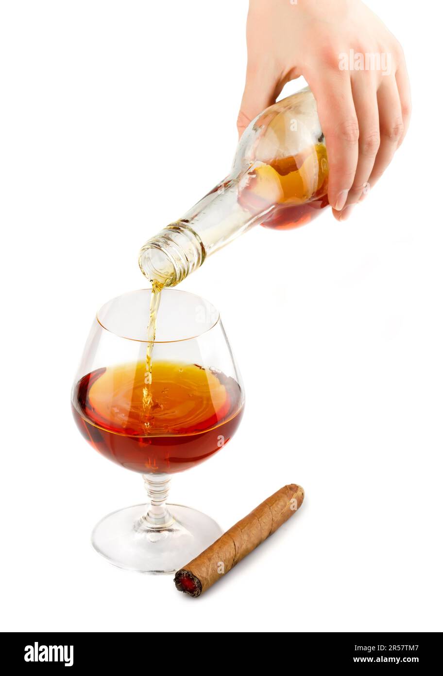 Pouring of cognac in glass with cigar isolated on white background ...