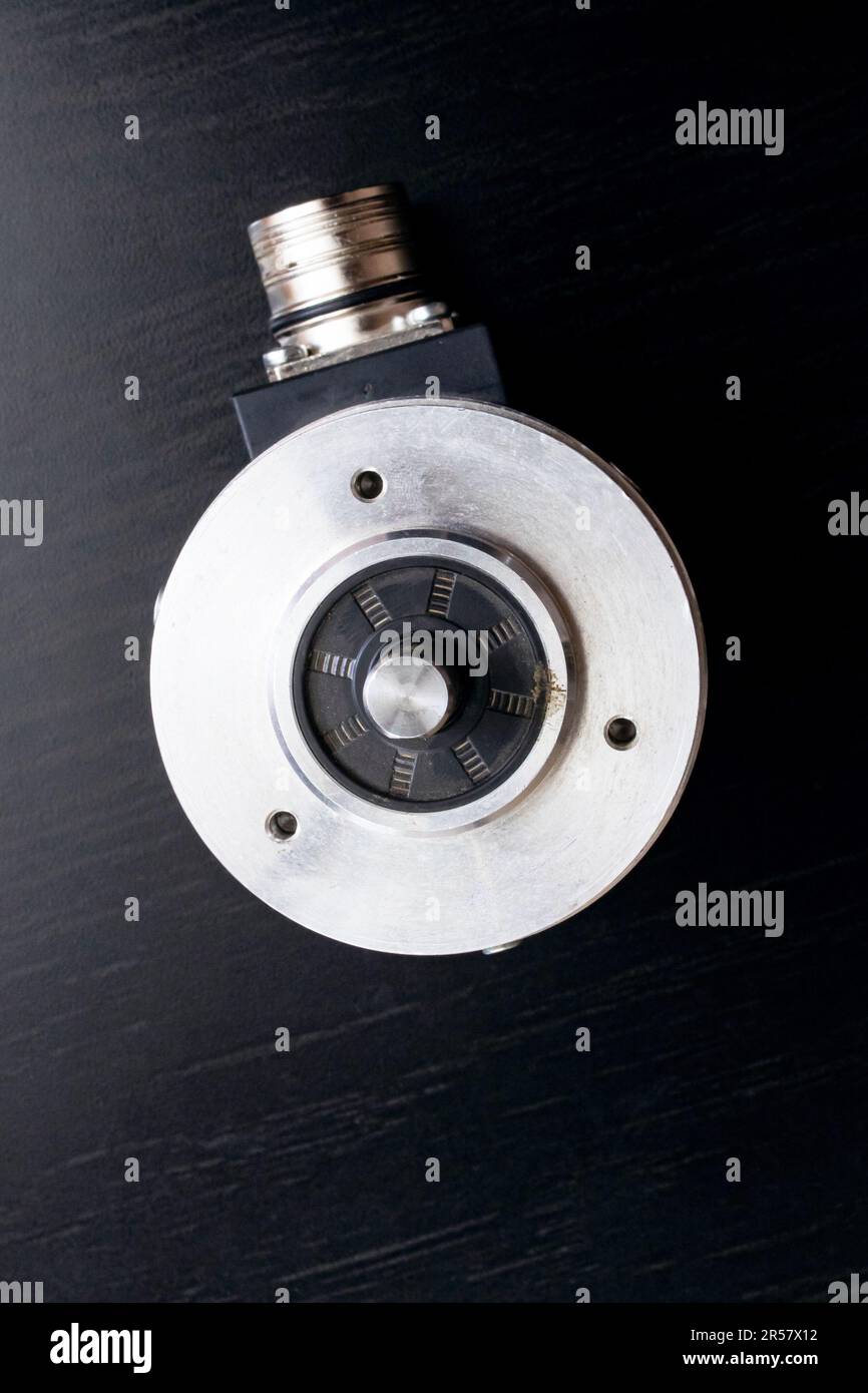 Metal encoder on a black wooden table, top view Stock Photo - Alamy