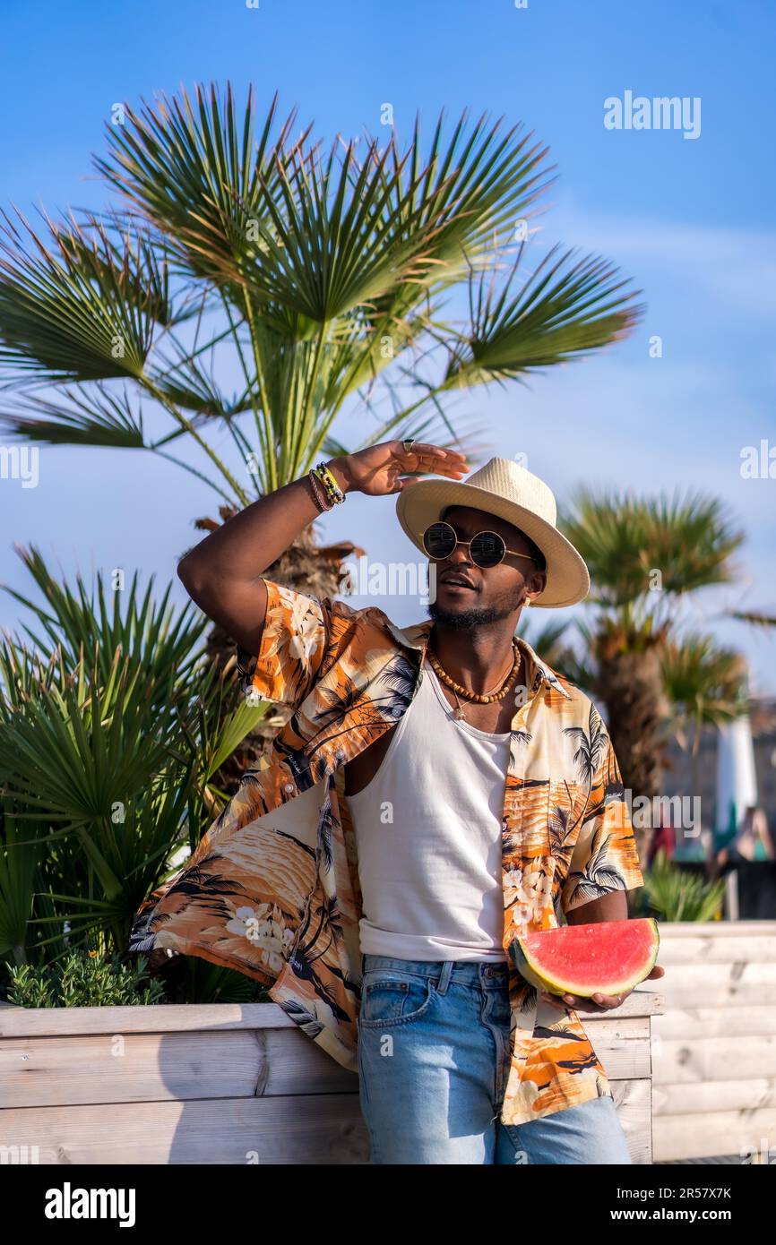 Black ethnic man enjoy summer vacation on the beach, sombrero and a ...