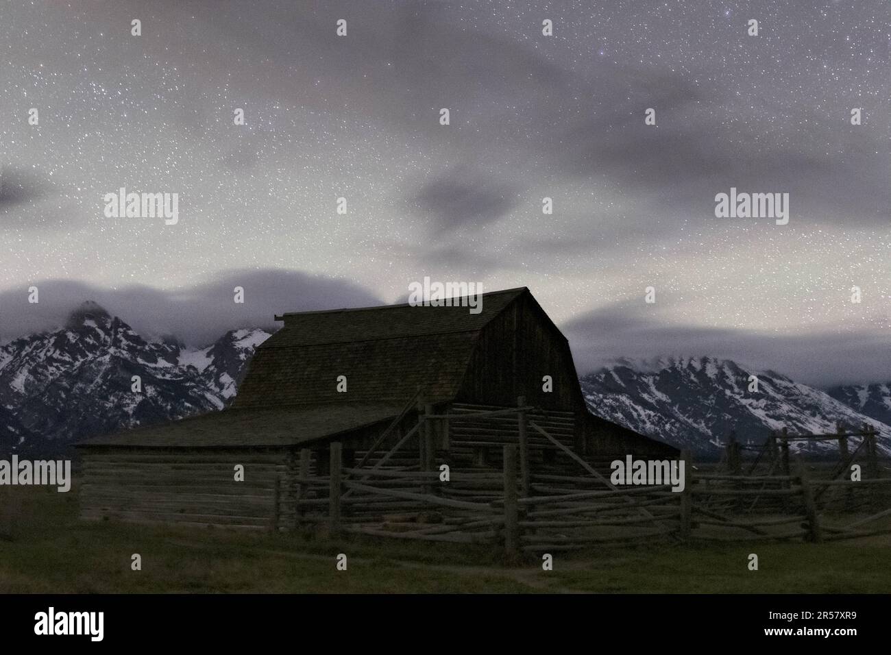 The John Moulton Barn rising below a starry night sky and the Teton ...