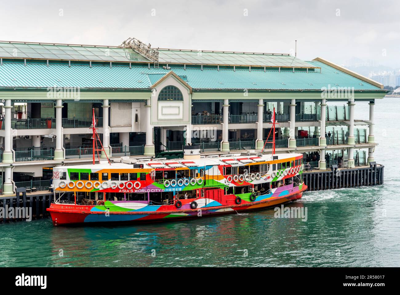 Passengers Wait To Board A Colourful Star Ferry From A Pier On Hong ...