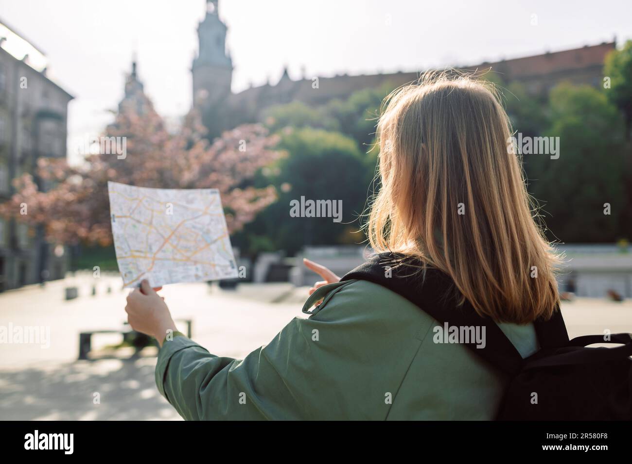 Young traveller woman walking on old town holding tourist map shows the ...