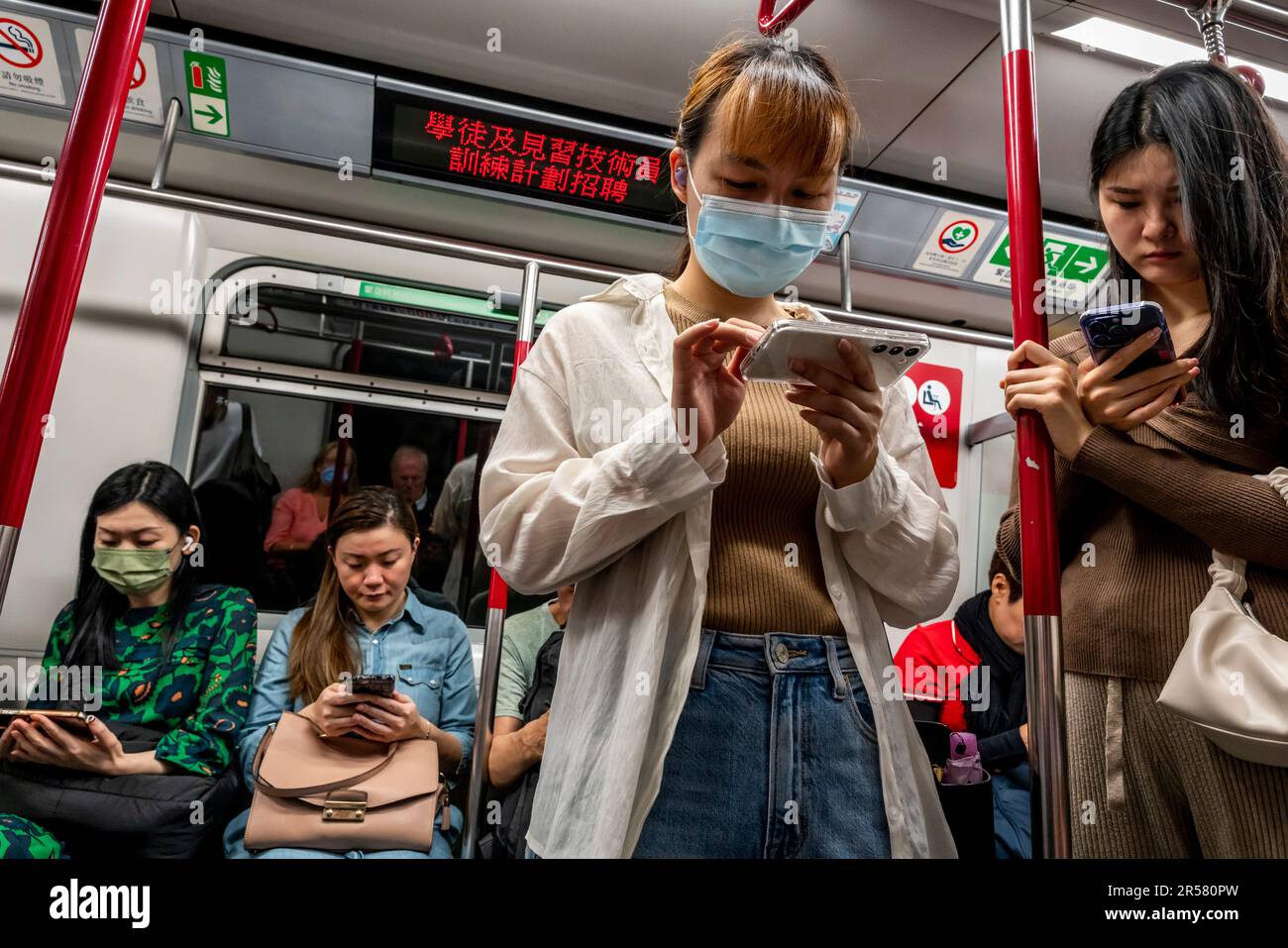 People Using Their Smartphones On A MTR Train, Hong Kong, China Stock ...