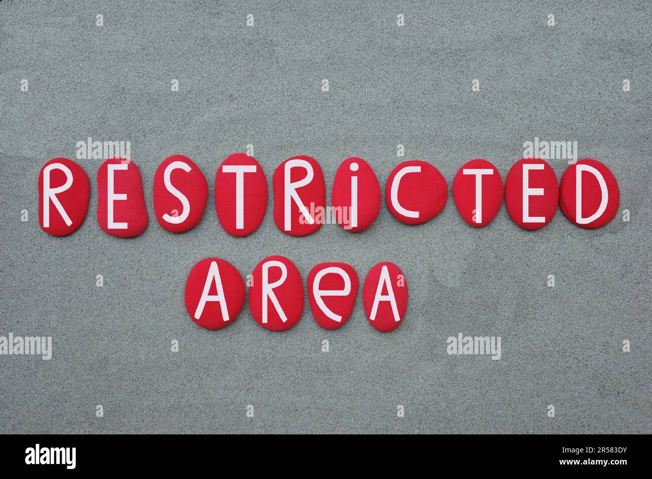Restricted Area, red painted stone letters composed over beach sand ...