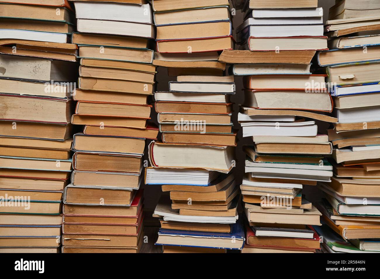 Wall of books piled up Stock Photo - Alamy