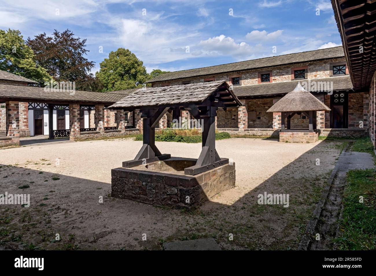 Well house with wooden roof and thatched roof, well in the courtyard of ...