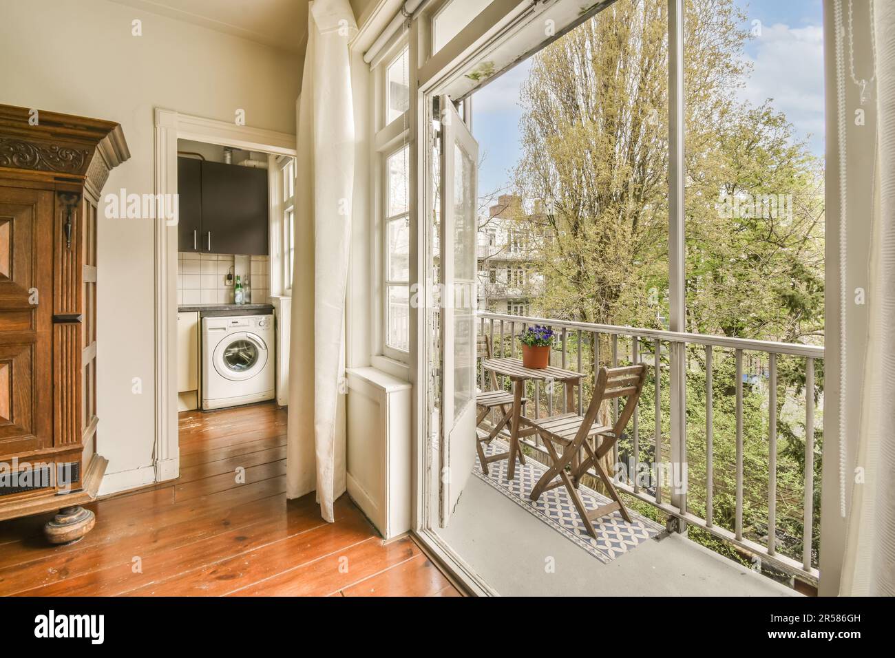 a balcony with a washing machine in the window and an open door that ...