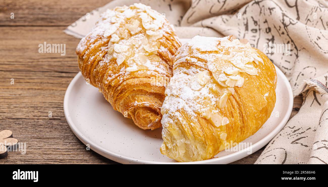 Good morning concept. Fresh croissants with cream filling and almond ...