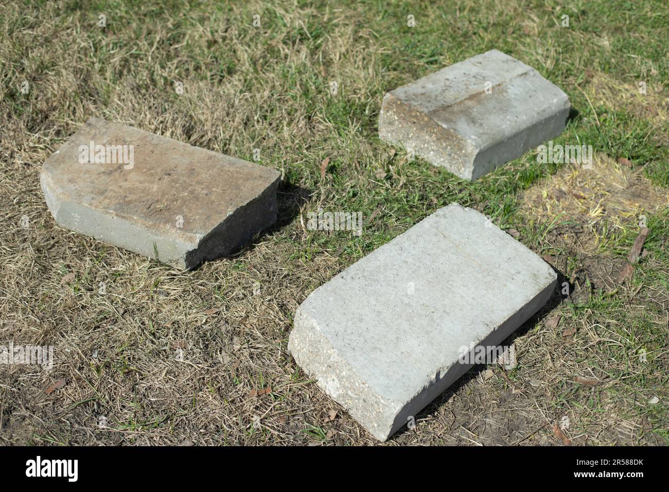 Concrete blocks lie on grass. Construction debris in park. Concrete ...