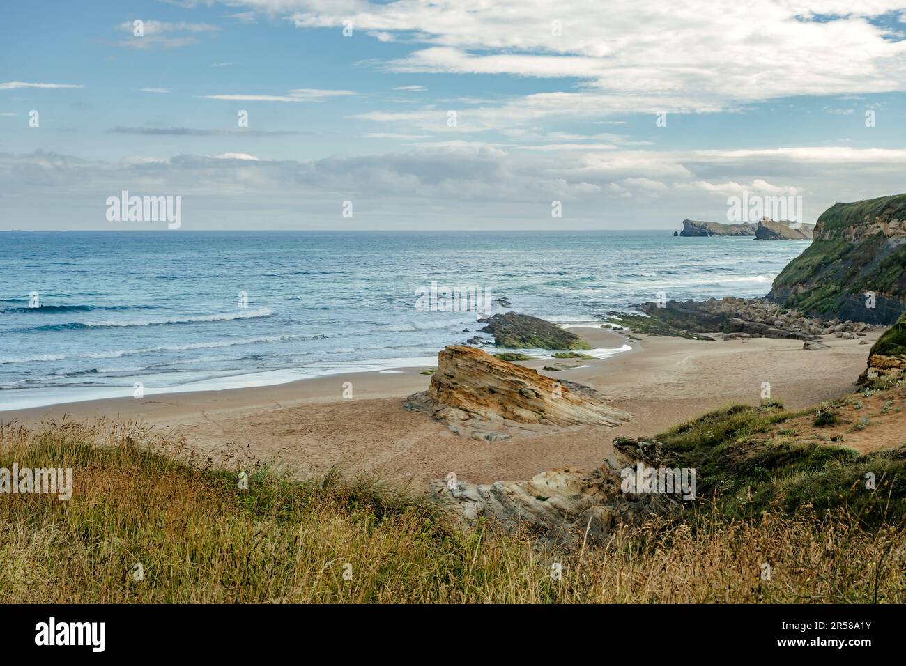 Rocky outcrops on a sandy beach in the Dunes of Liencres Natural Park ...