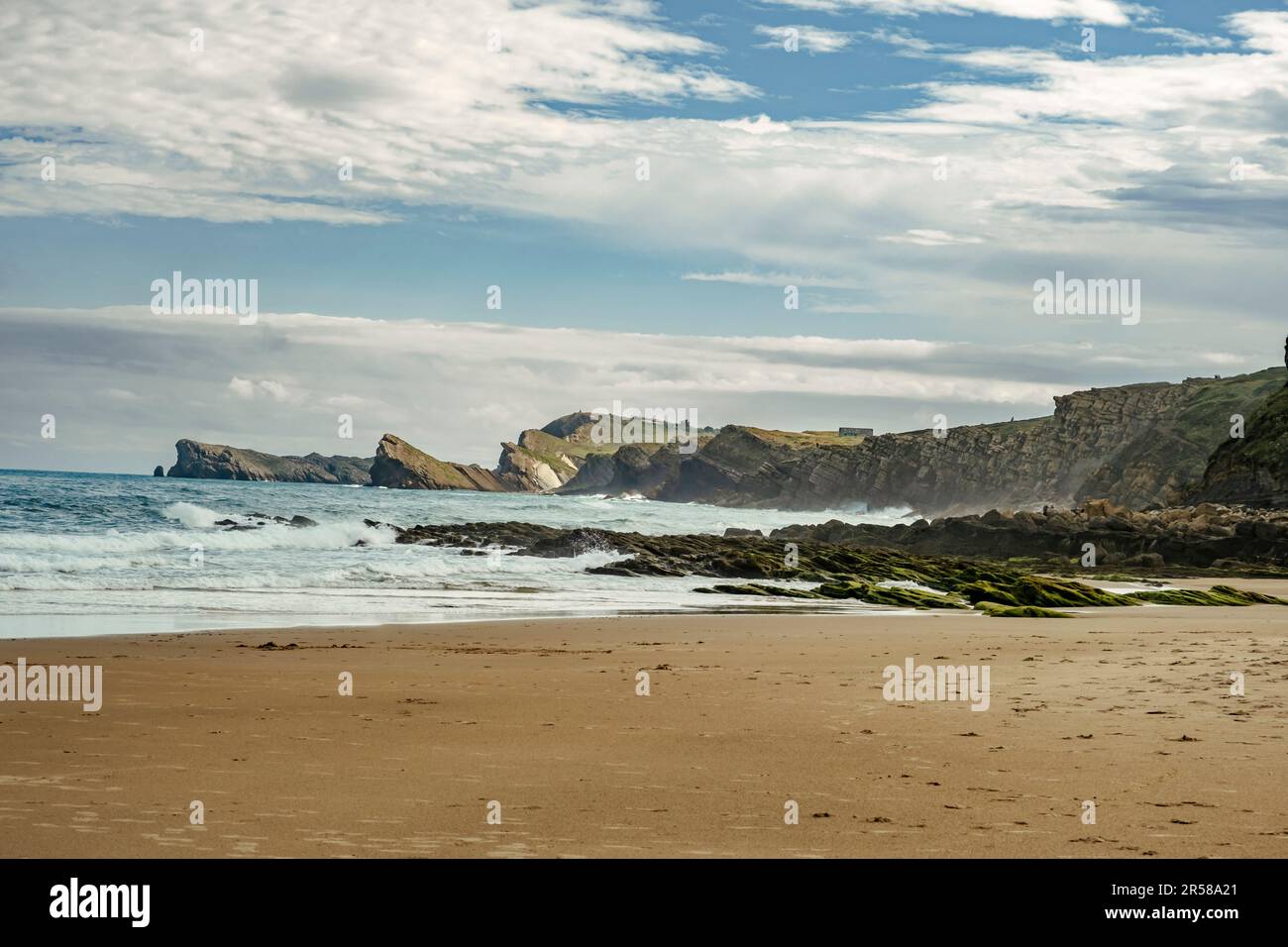 Sandy beach and steep cliffs in Dunes of Liencres Natural Park ...