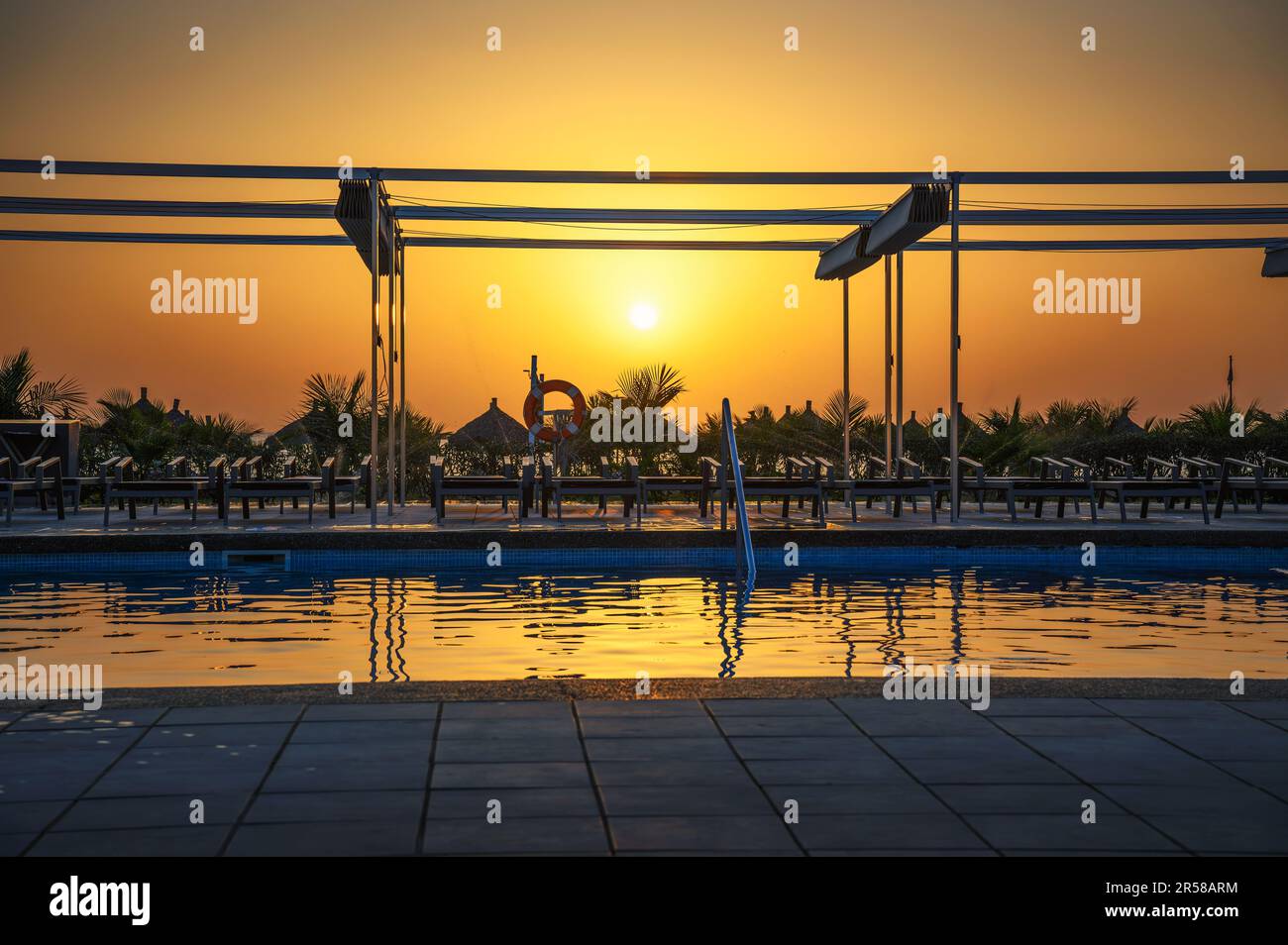 Sunset above a swimming pool, Atlantic Ocean and a beach in Senegal ...