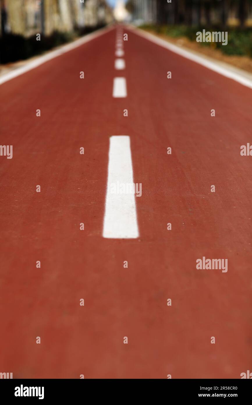 New red bikepath or pedestrian path separated by white line, traffic ...