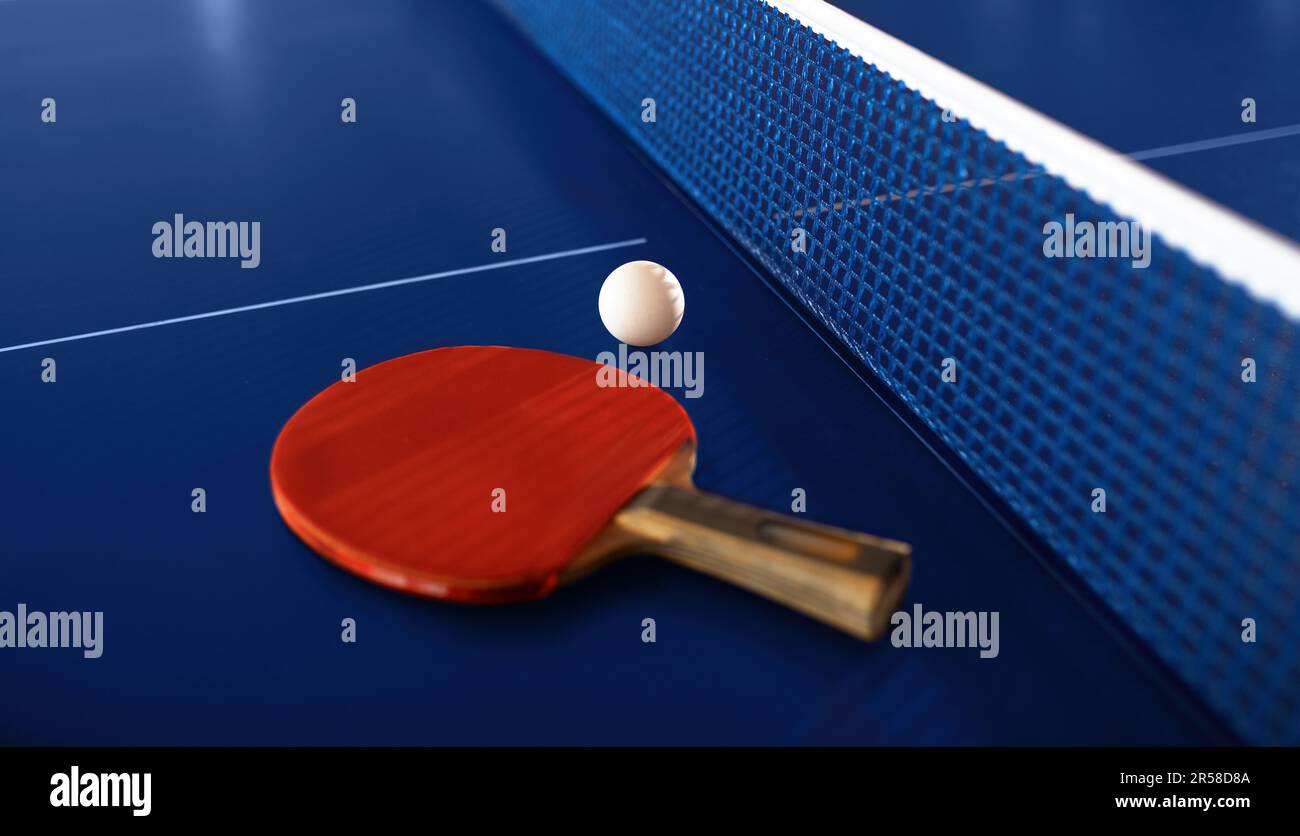 Tennis racket and ball on ping-pong table with net prepared for game ...