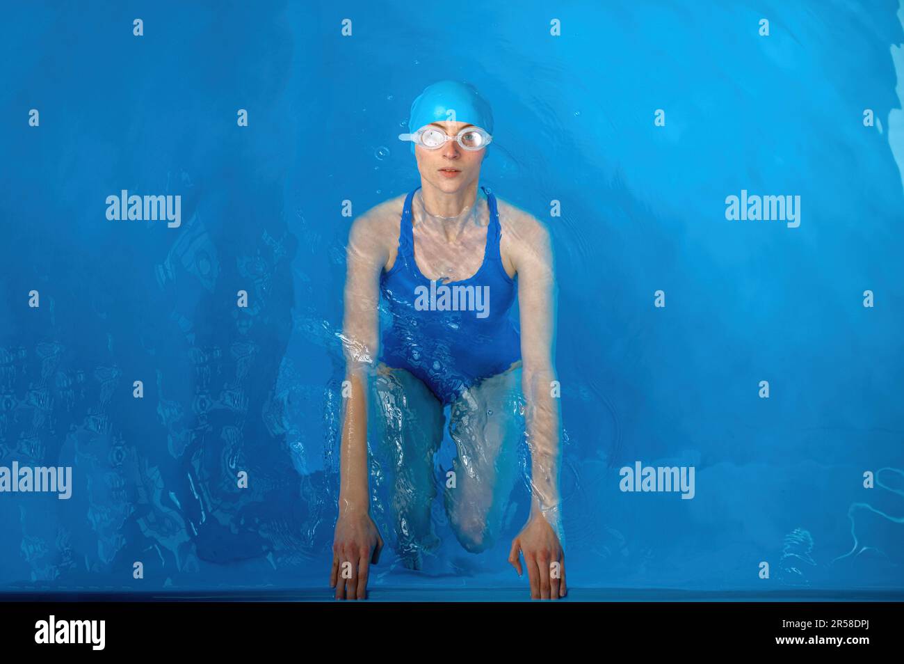 Top view on young sportswoman training backstroke in indoor swimming ...