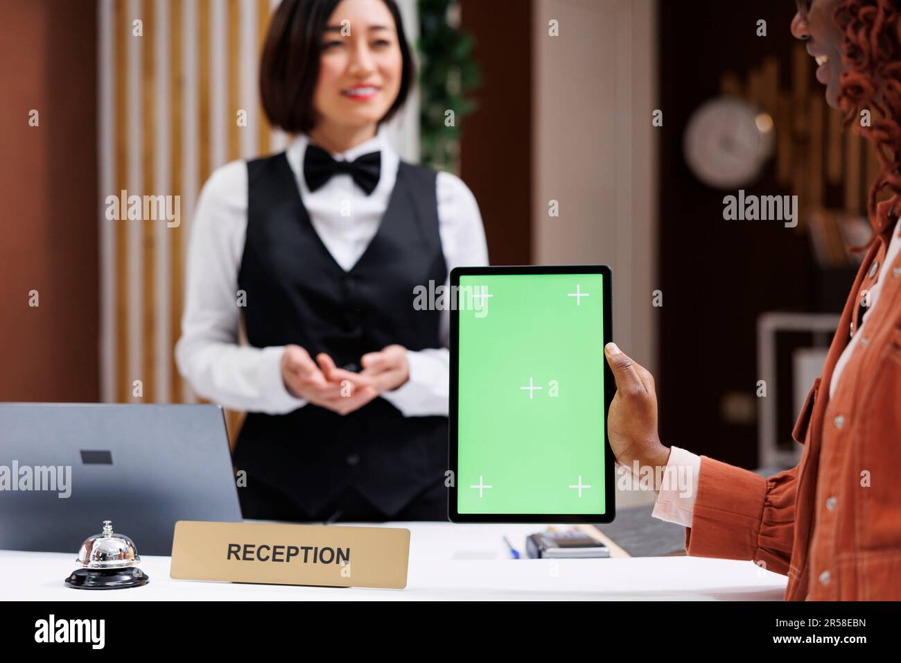 Guest using greenscreen at check in, talking to receptionist about ...