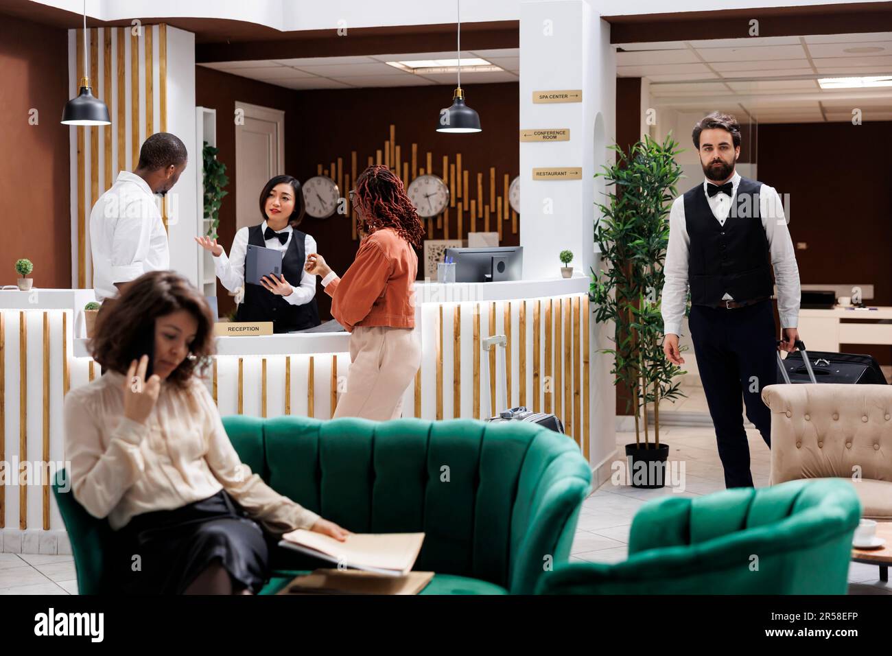 Asian receptionist welcoming people in lobby, providing luxury service ...
