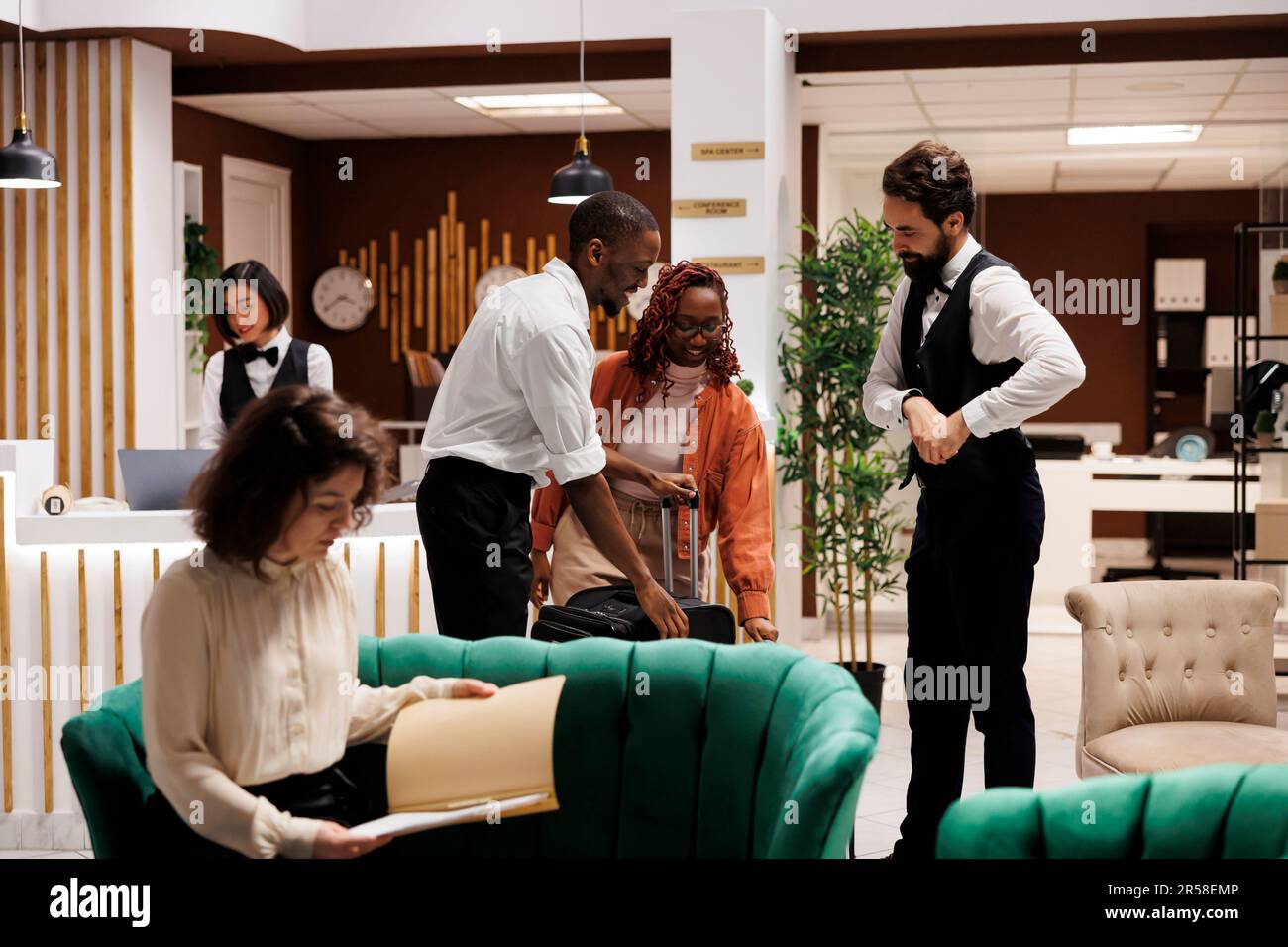 Hotel concierge assisting guests in lobby, helping with check in ...