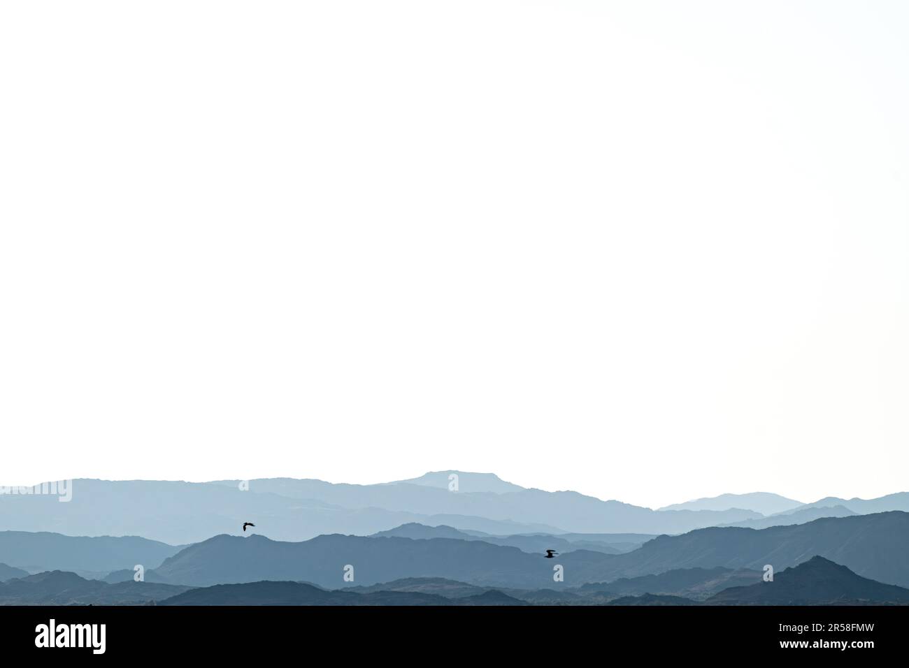 Beautiful layers of mountains with birds flying Stock Photo - Alamy