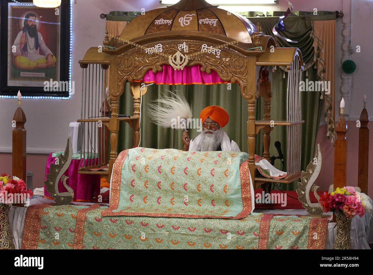 Priest (Bhai) Ram Singh is shown performing rituals by the Holy Book ...