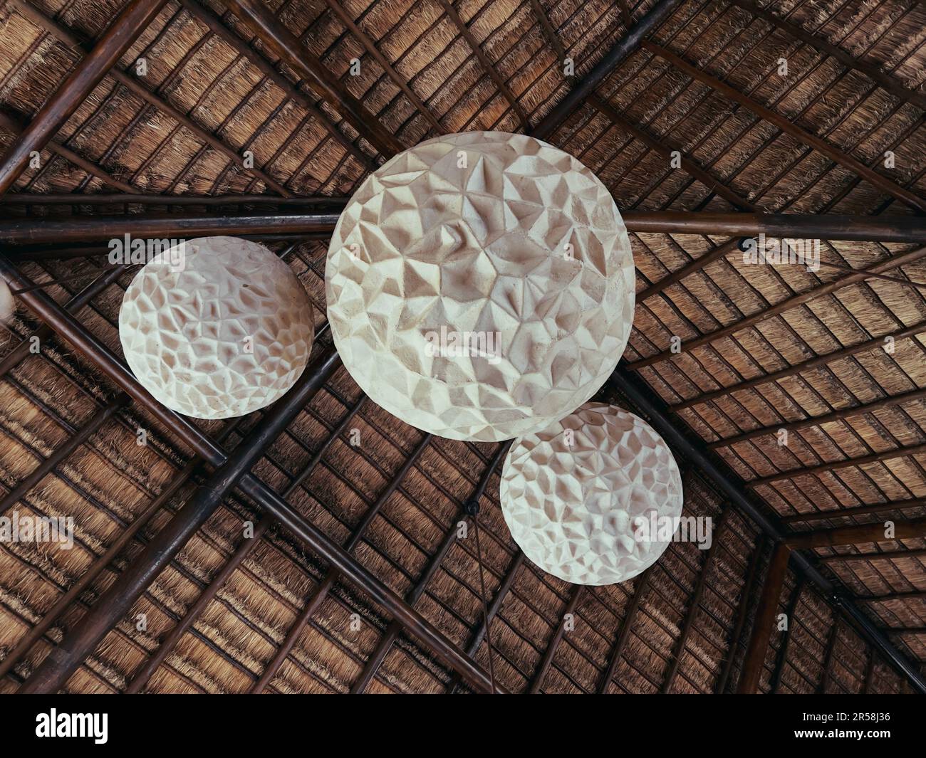 Looking up at decorative spheres with indented designs hanging from ...