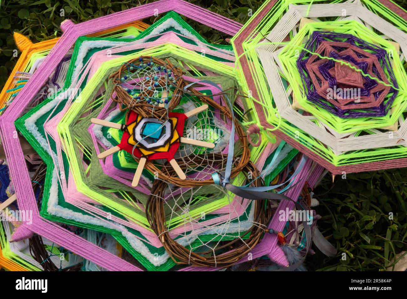 Indian amulets-mandalas "Ojos de dios" (God's eyes) are seen on a grass ...