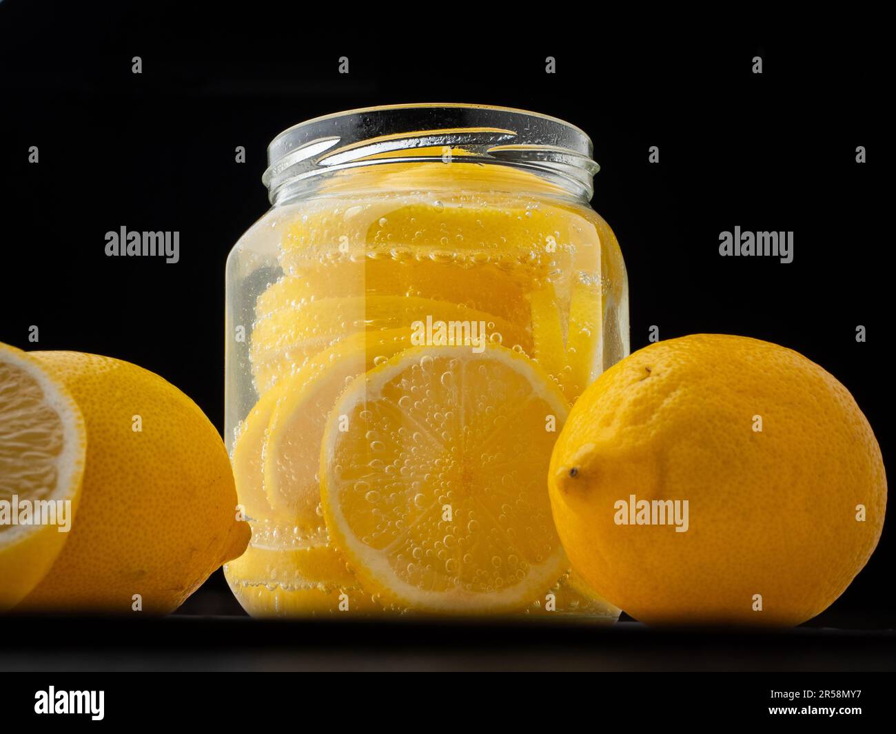 Lemon slices in glass jar filled up with refreshing soda. Black ...